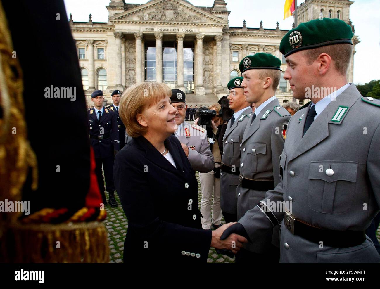 German Chancellor Angela Merkel congratulates a new recruit of German ...