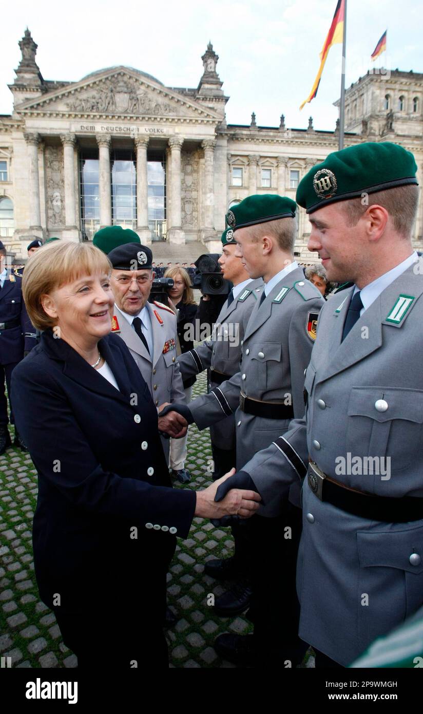 German Chancellor Angela Merkel , right, congratulates a new recruit of ...