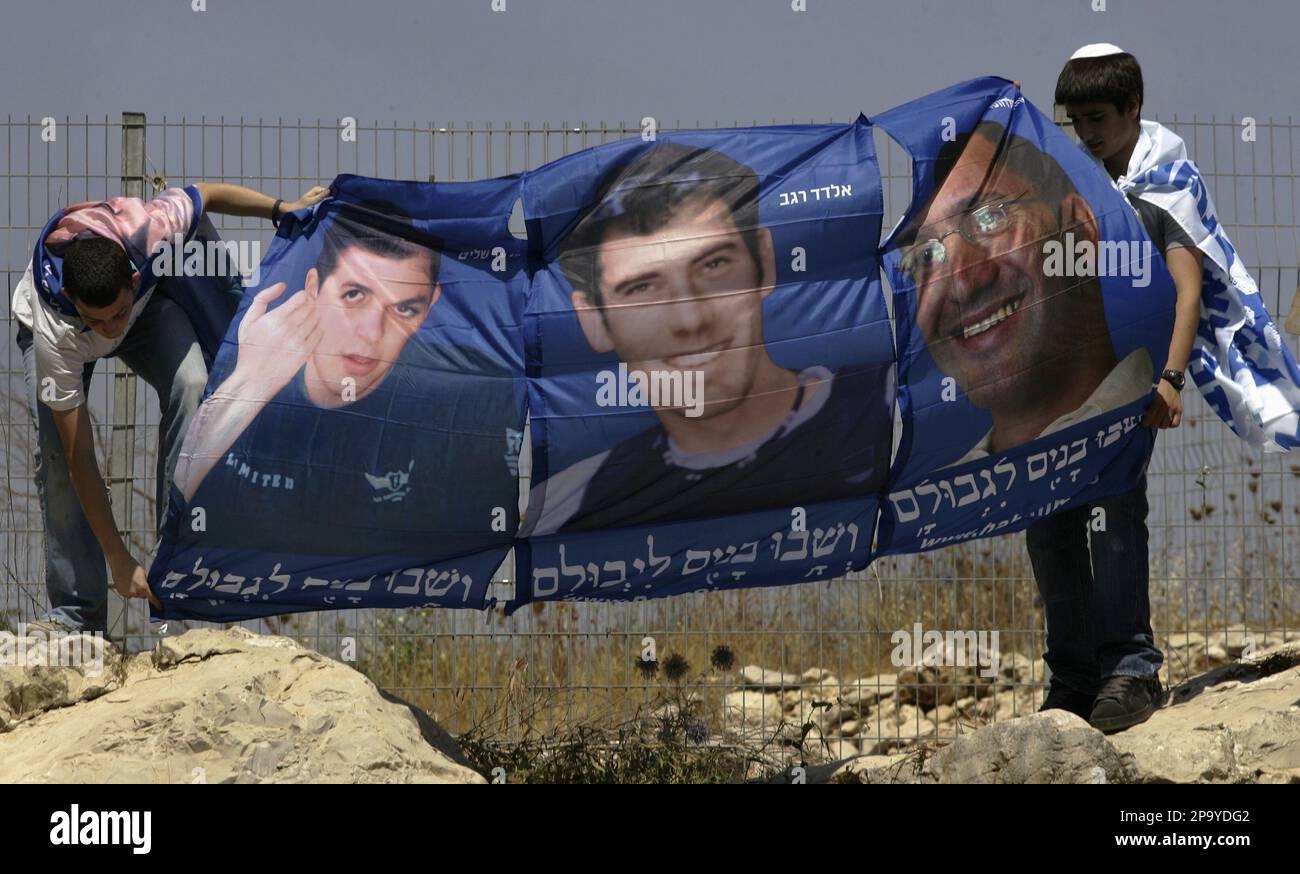 Israelis hold banners of captured Israeli soldiers Ehud Goldwasser ...