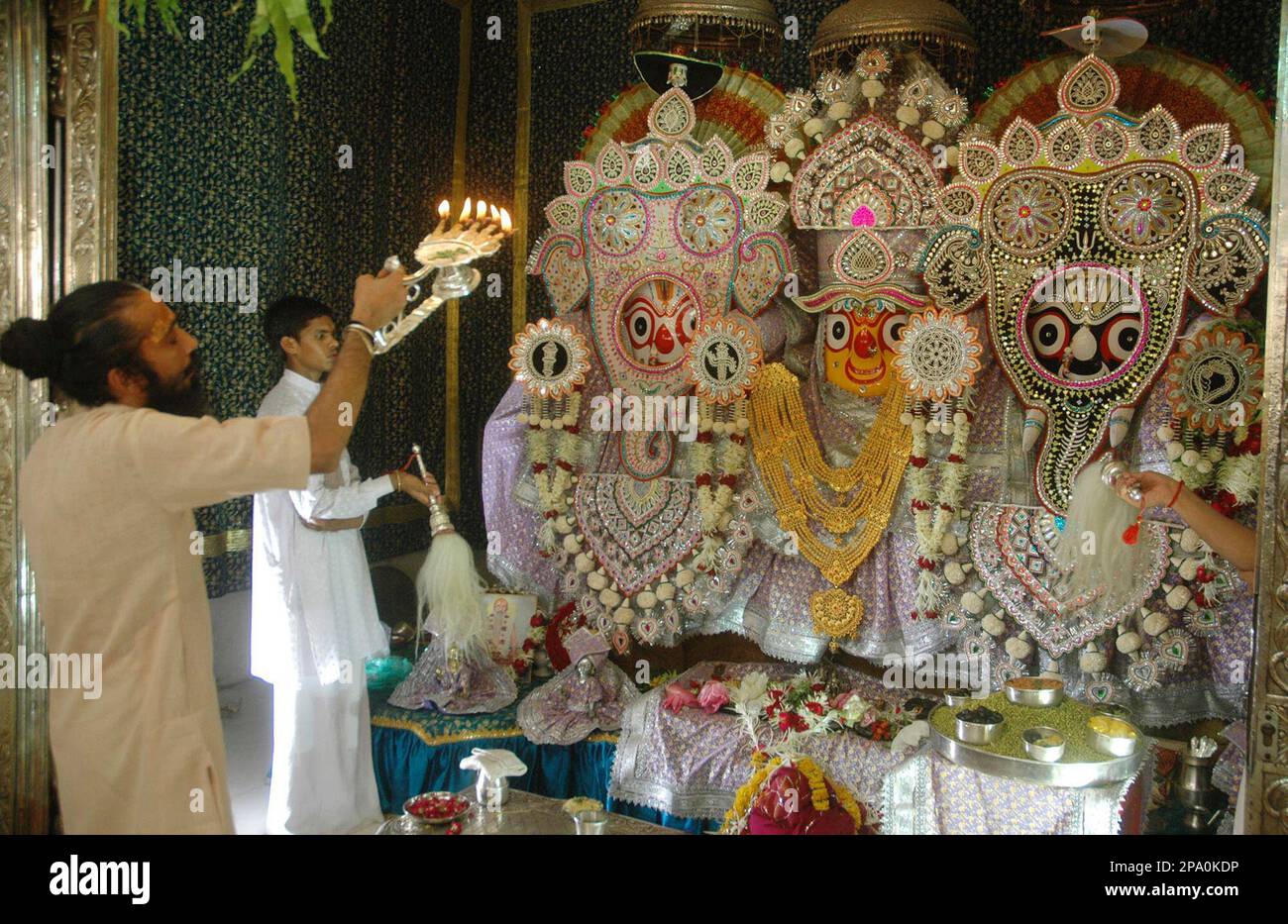 A Hindu priest performs puja or prayer during a religious procession ...