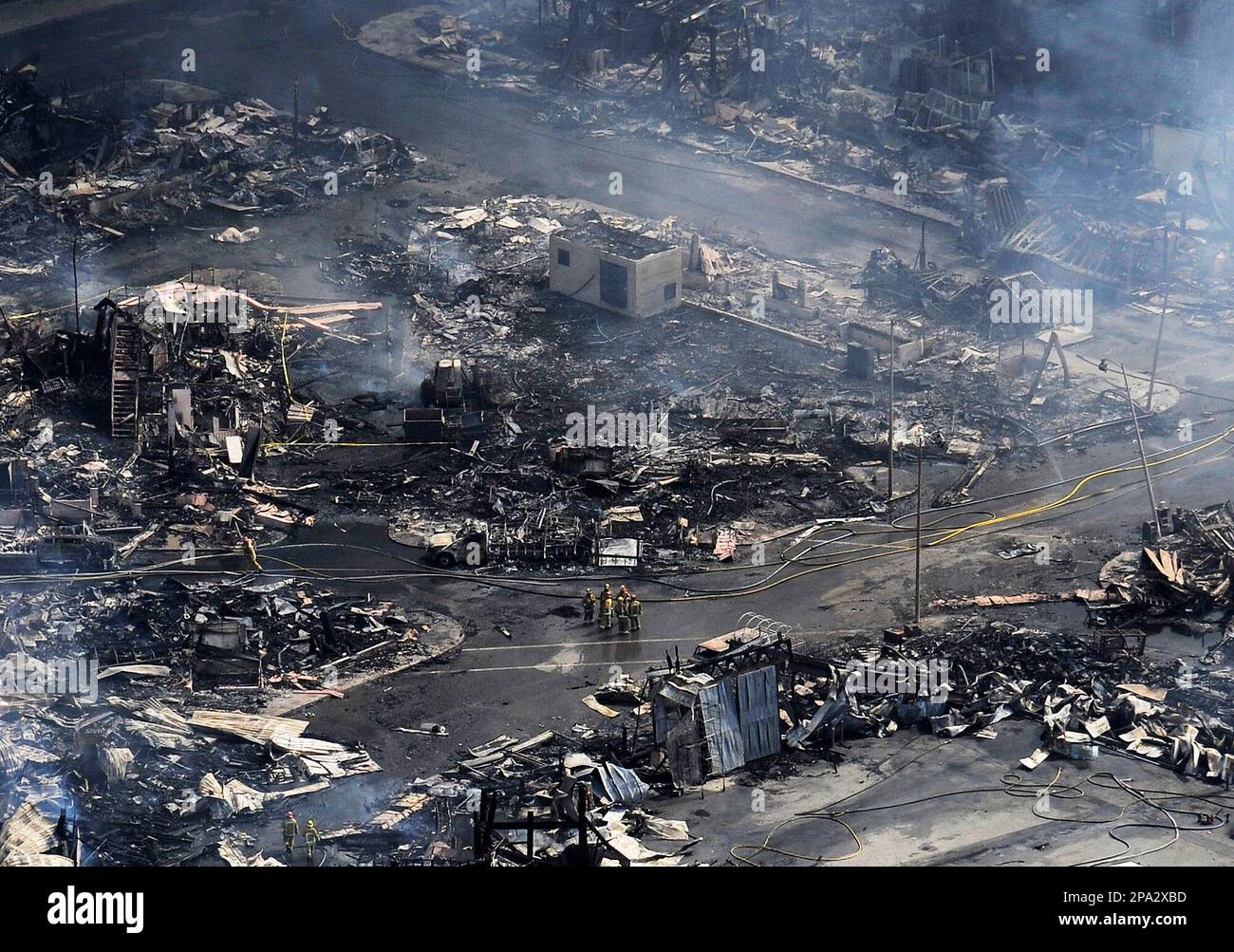 Los Angeles City firefighters stand in the middle of destroyed sets and ...