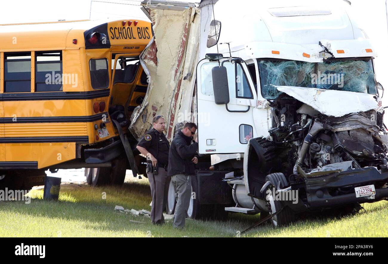 Emergency personnel look at a semi and a school bus involved in ...