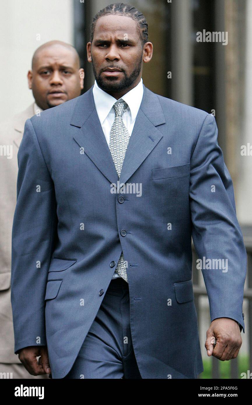 Singer R. Kelly, right, leaves with a bodyguard after the first day of ...