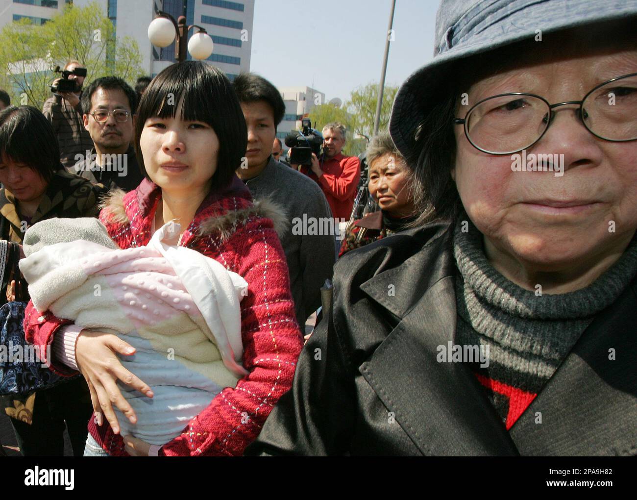 Zeng Jinyan, the wife of civil rights activist Hu Jia, left, carries ...