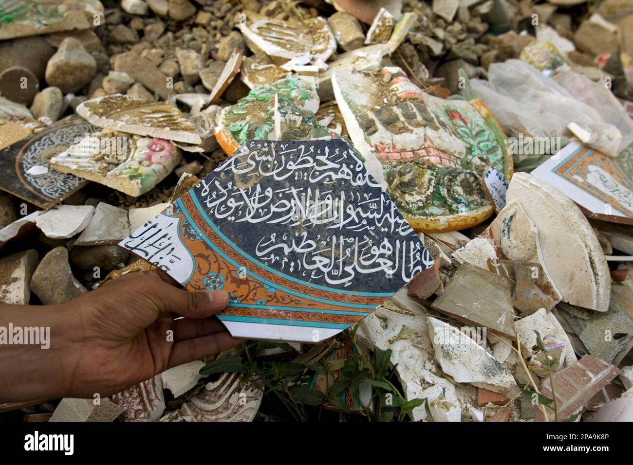 A visitor shows broken souvenir carry Quranic verses outside caves ...