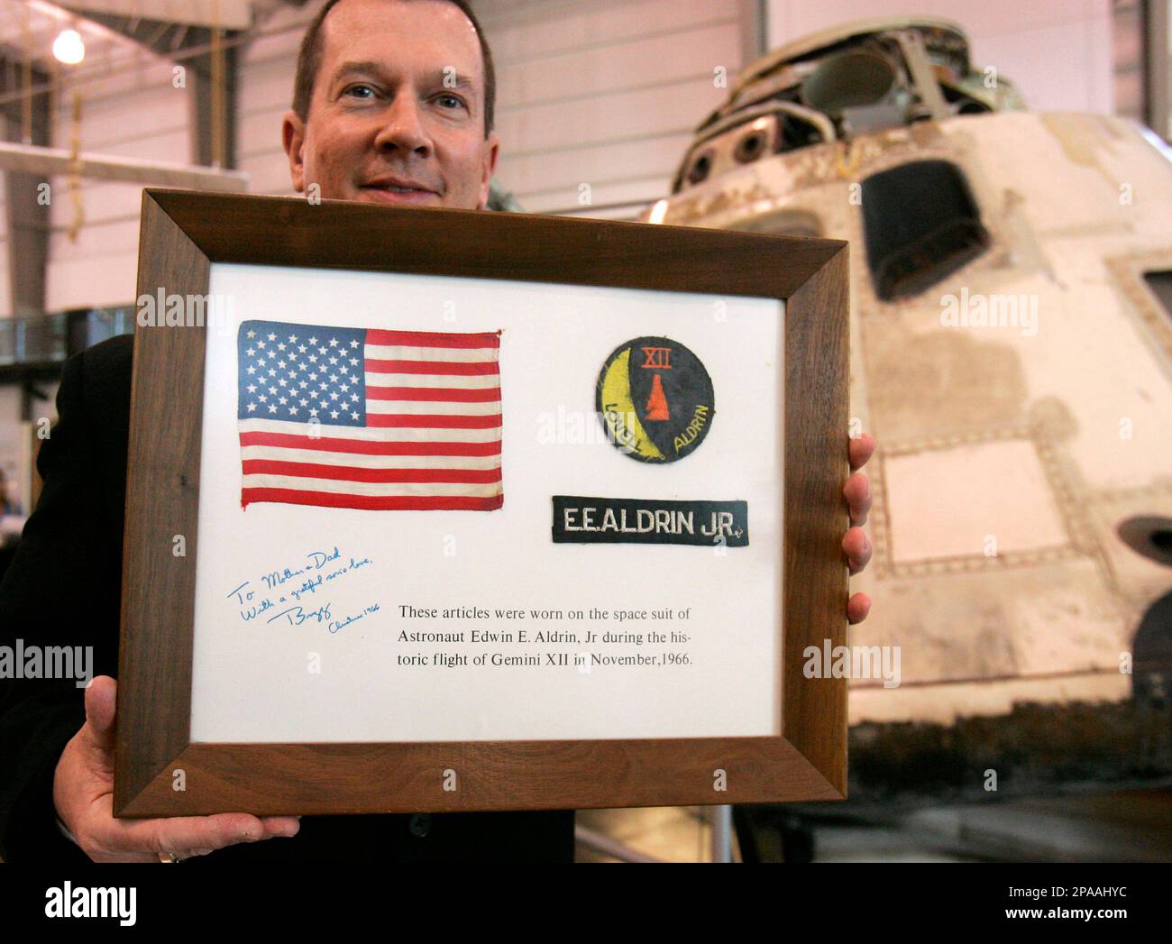 Les Johnson holds framed patches from Buzz Aldrin's Gemin 12 space ...