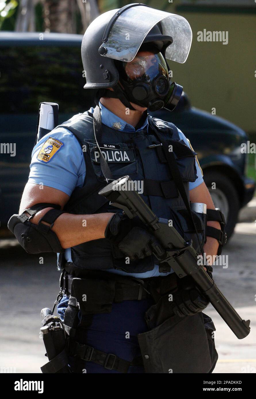 A Police officer, in full anti-riot gear, stands guard outside a school ...