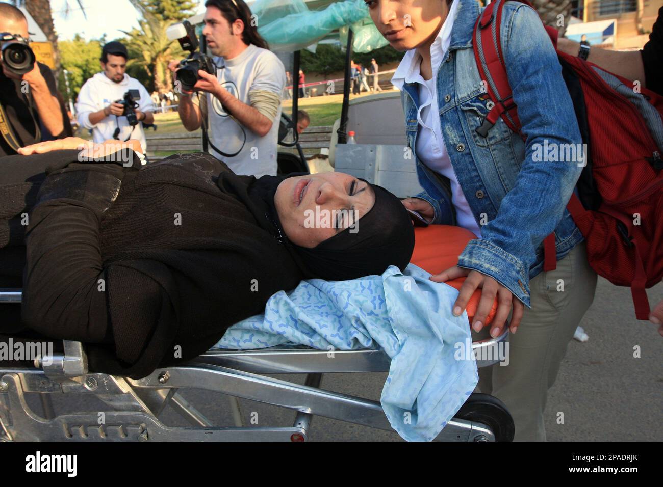A wounded woman is taken for treatment after a rocket fired by ...