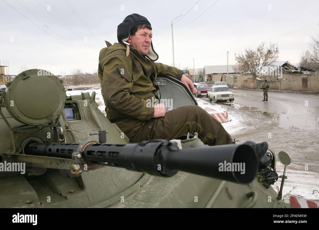 A Chechen contract serviceman, working for the Russian army, sits atop ...