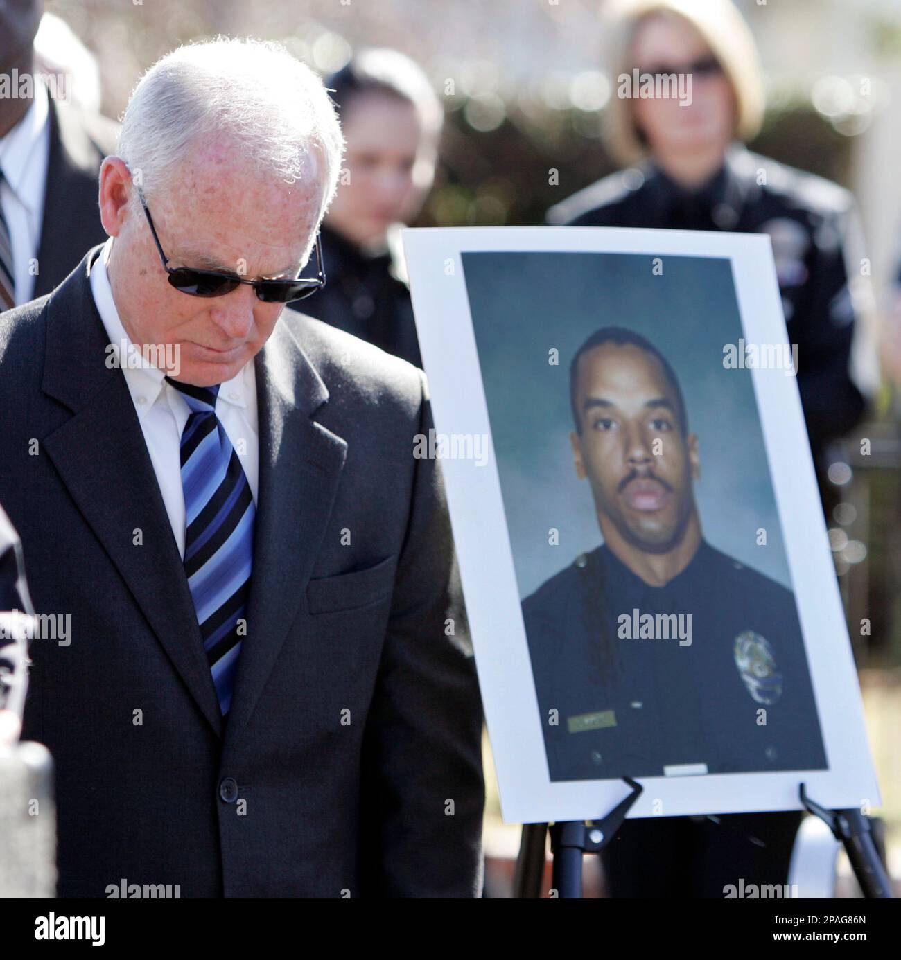 Los Angeles Police Deputy Chief Gary Brennan stands next to a portrait ...
