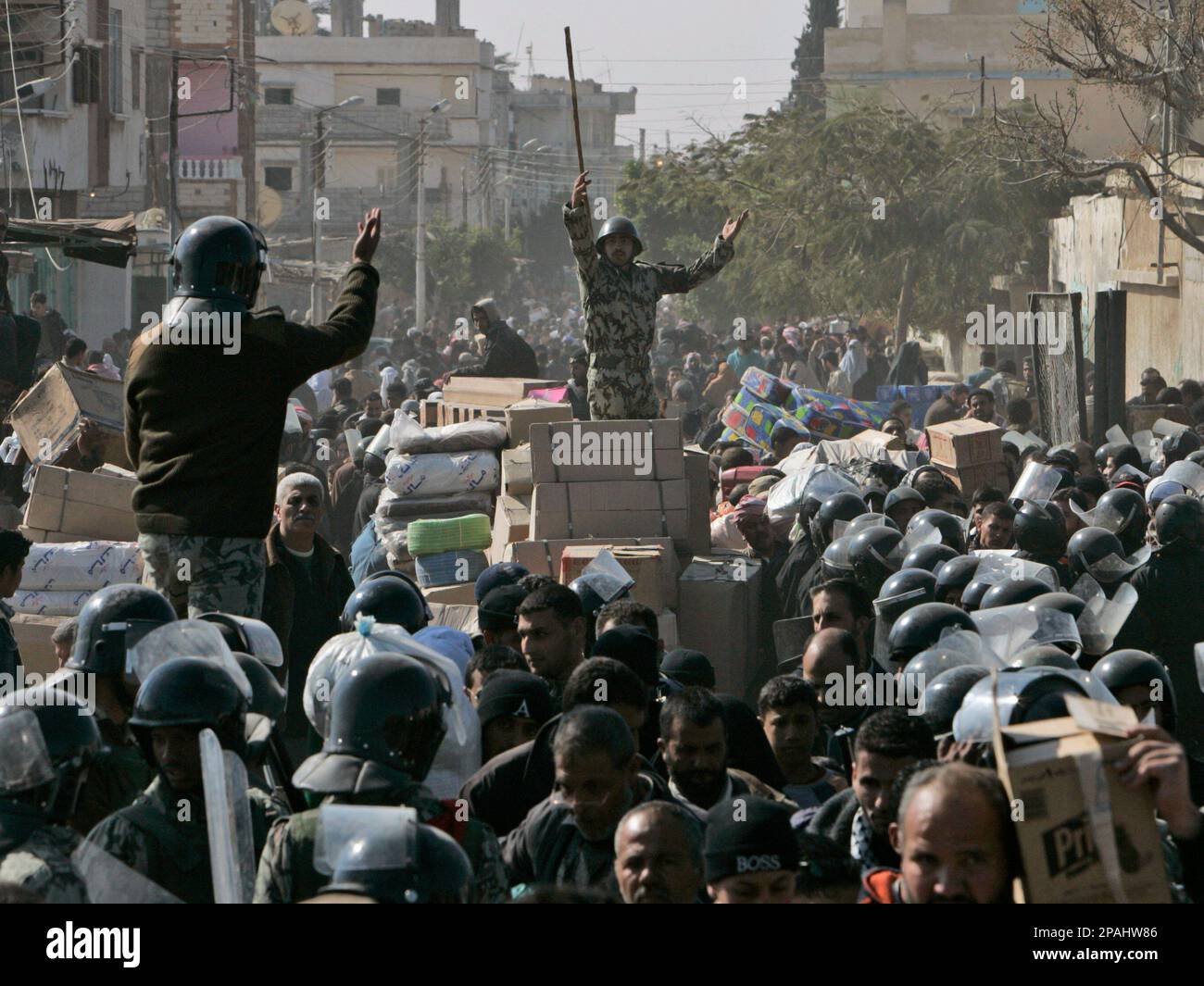 Egyptian border guards and riot police officers try to control the ...
