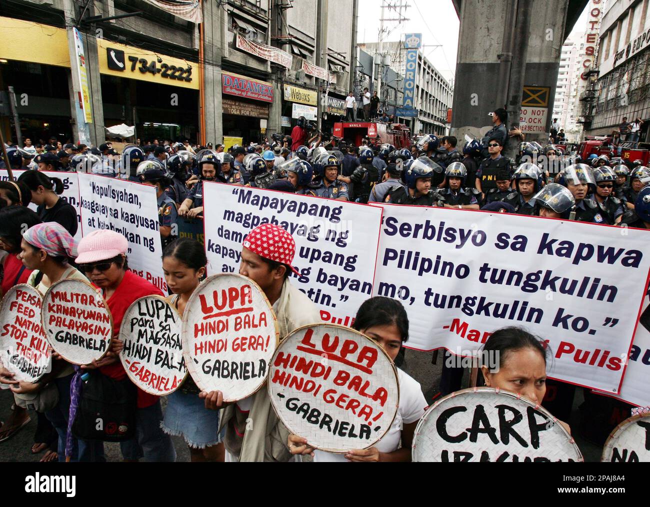 Protesters hold placards as they line up in front of riot police, also ...
