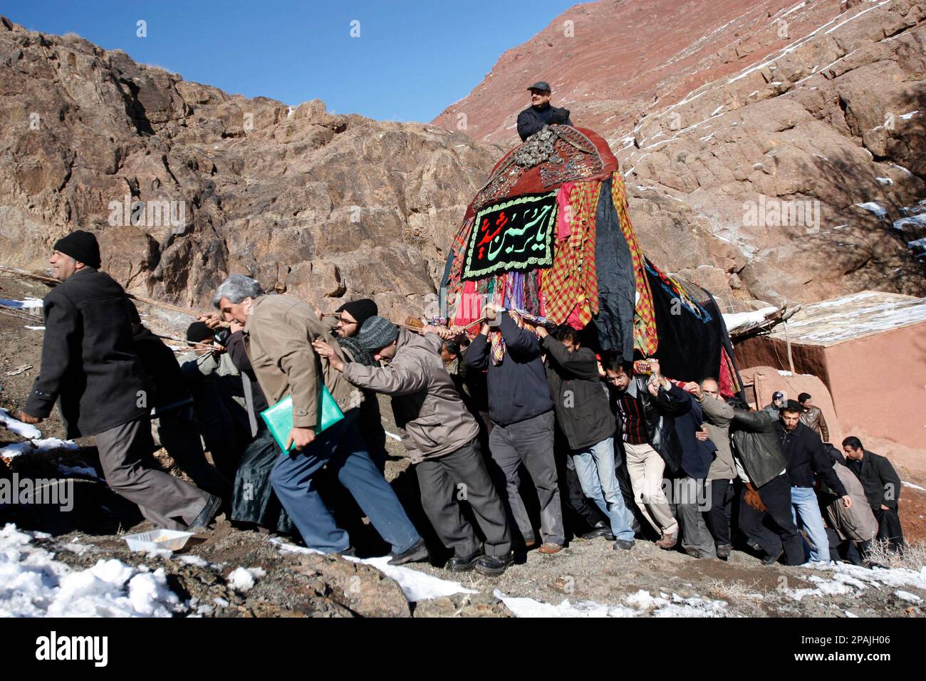 Iranian men carry a funeral litter representing one containing the body ...