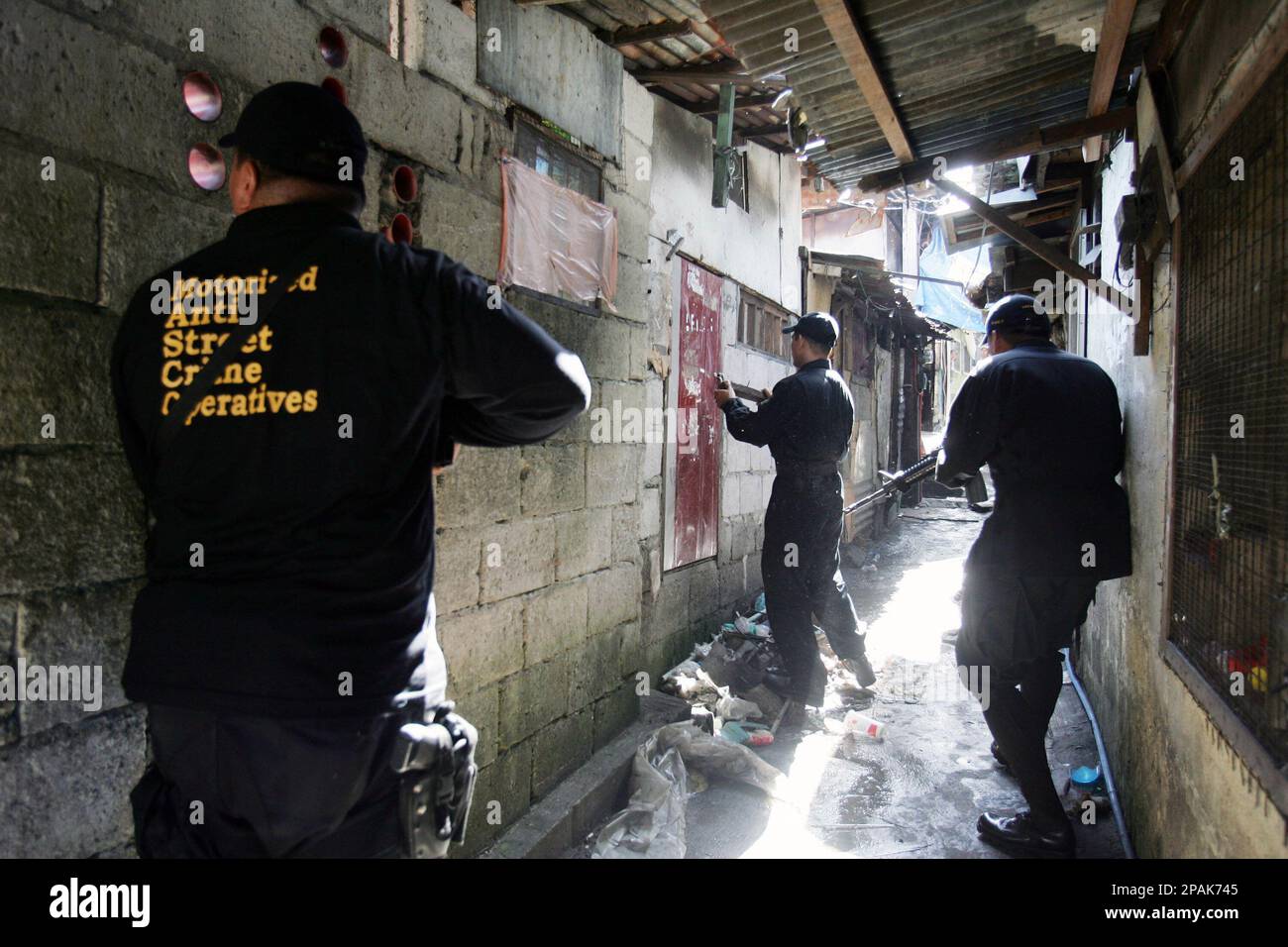 Philippine National Police SWAT members search for a slum dweller who ...
