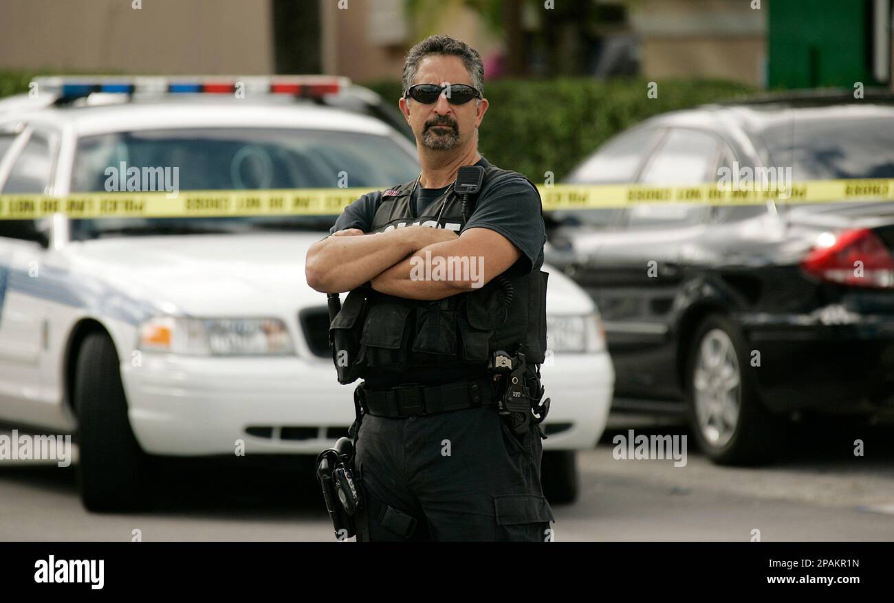 A Miami area police officer guards the secured area around the crime ...