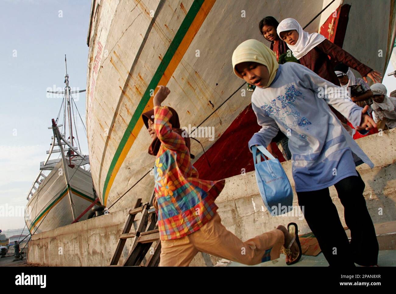 Indonesian Muslims make there way by boat to a mosque near a ...