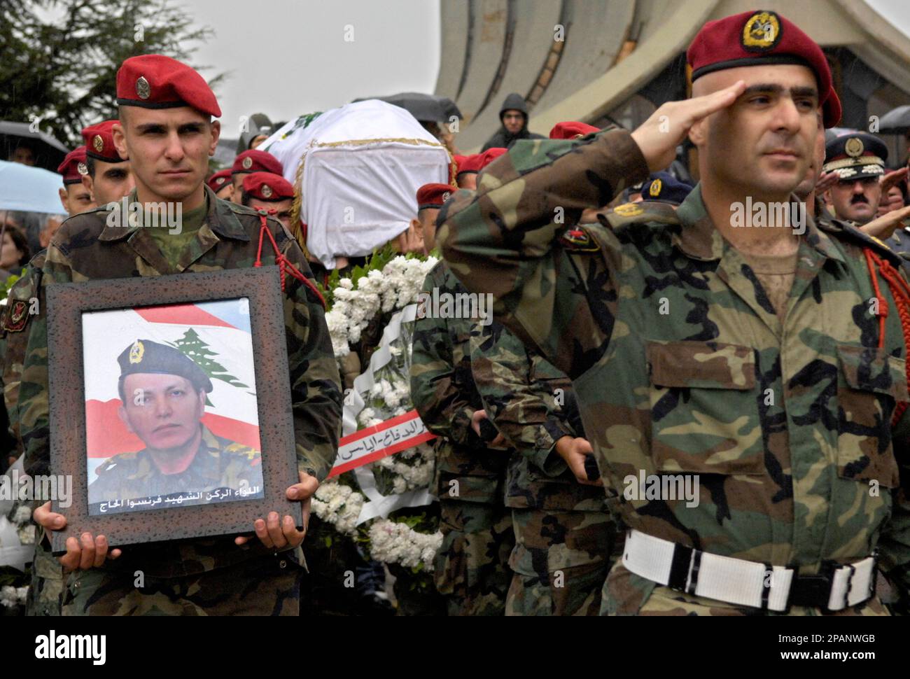 A Lebanese soldier salutes, right, as another holds a picture of slain ...