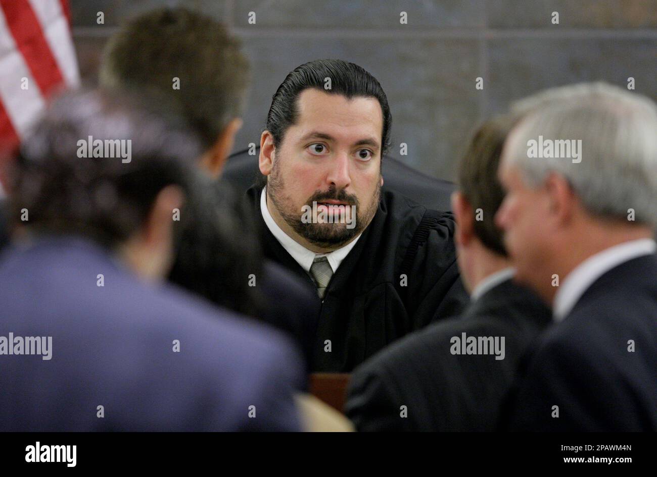 Judge Joe Bonaventure Jr., center, talks to lawyers in a courtroom ...