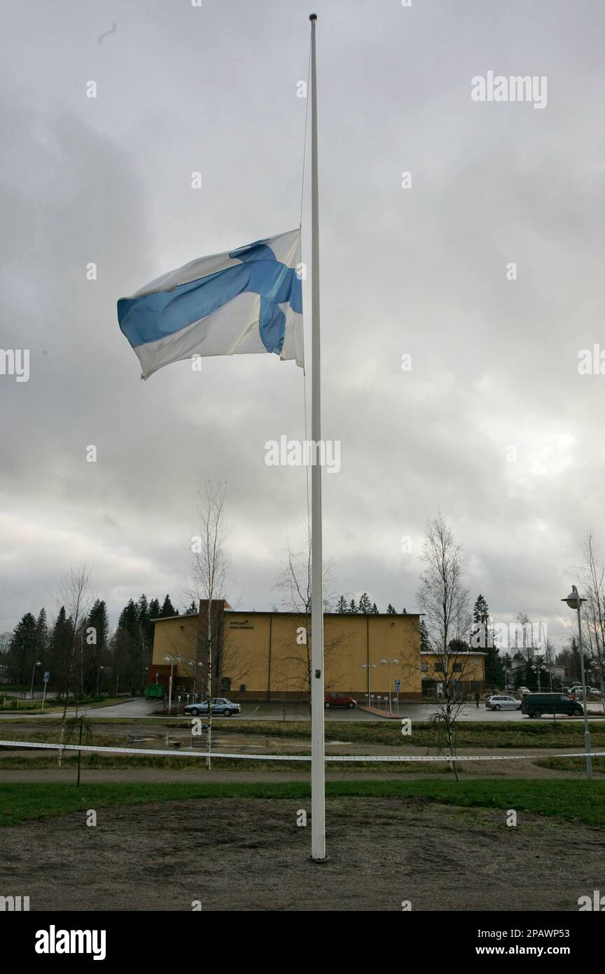 The Finnish flag flies half staff outside Jokela school, rear, in ...