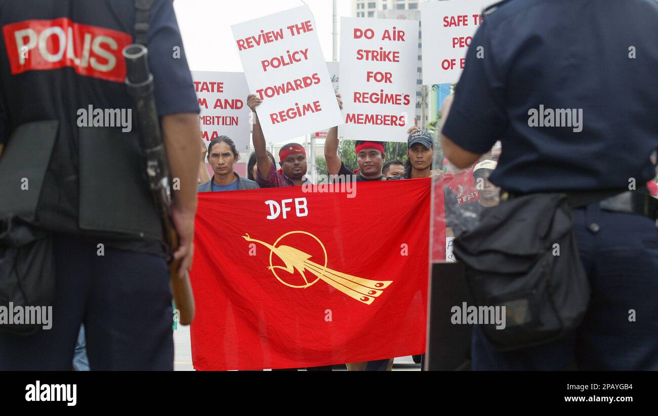Two Malaysian riot police, foreground, stand guard as Myanmar activists ...