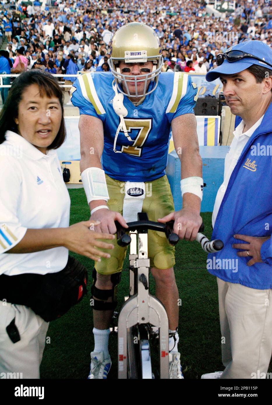UCLA quarterback Ben Olson, center, is checked the training staff after ...