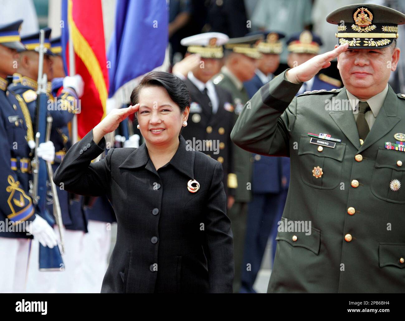 Philippine President Gloria Macapagal Arroyo, left, salutes beside Vice ...