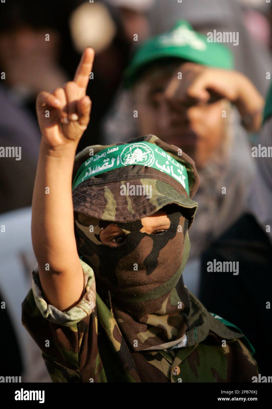 A masked Palestinian boy gestures during a Hamas rally calling for the ...