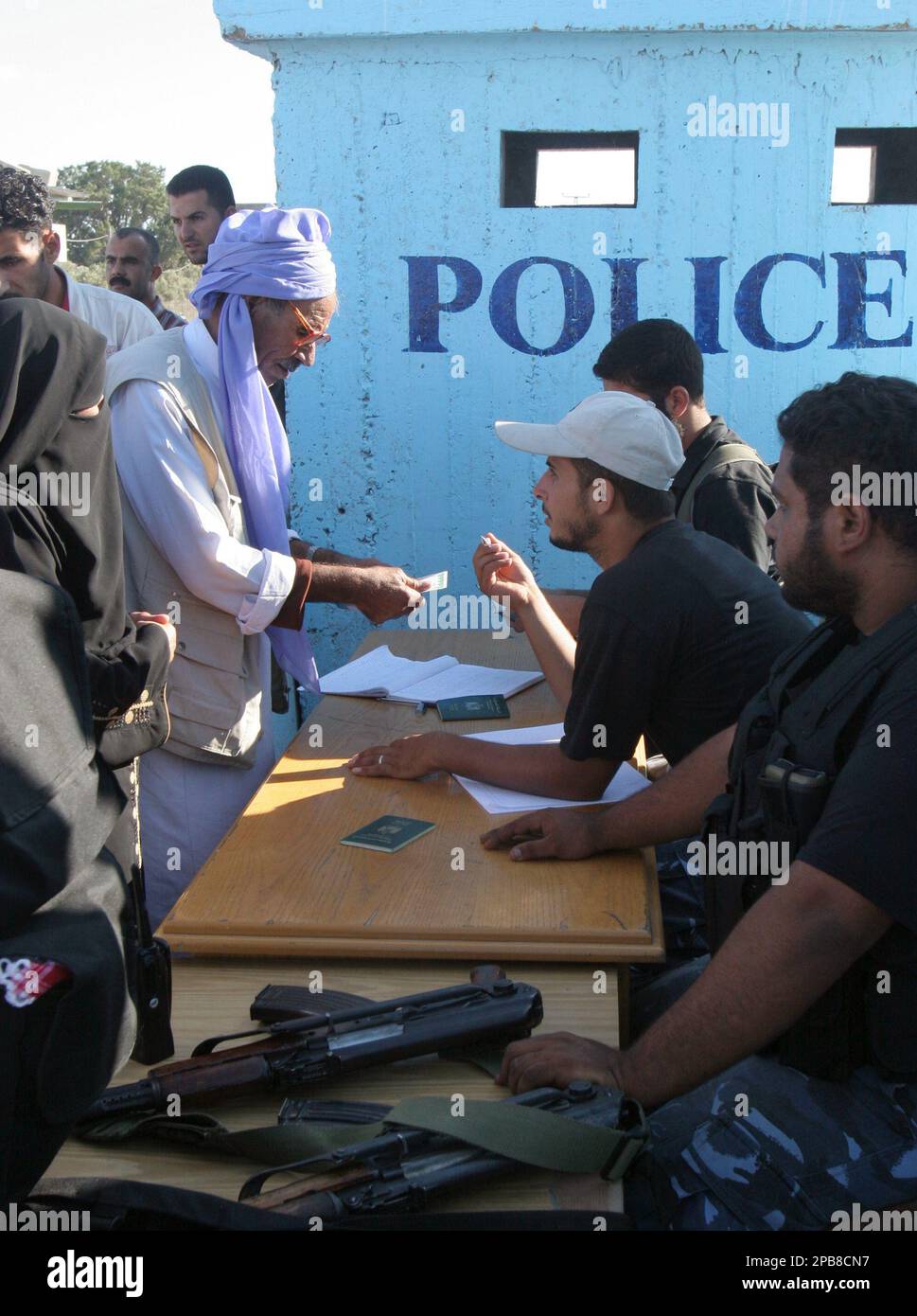 Hamas security officers check and register the travel documents of ...