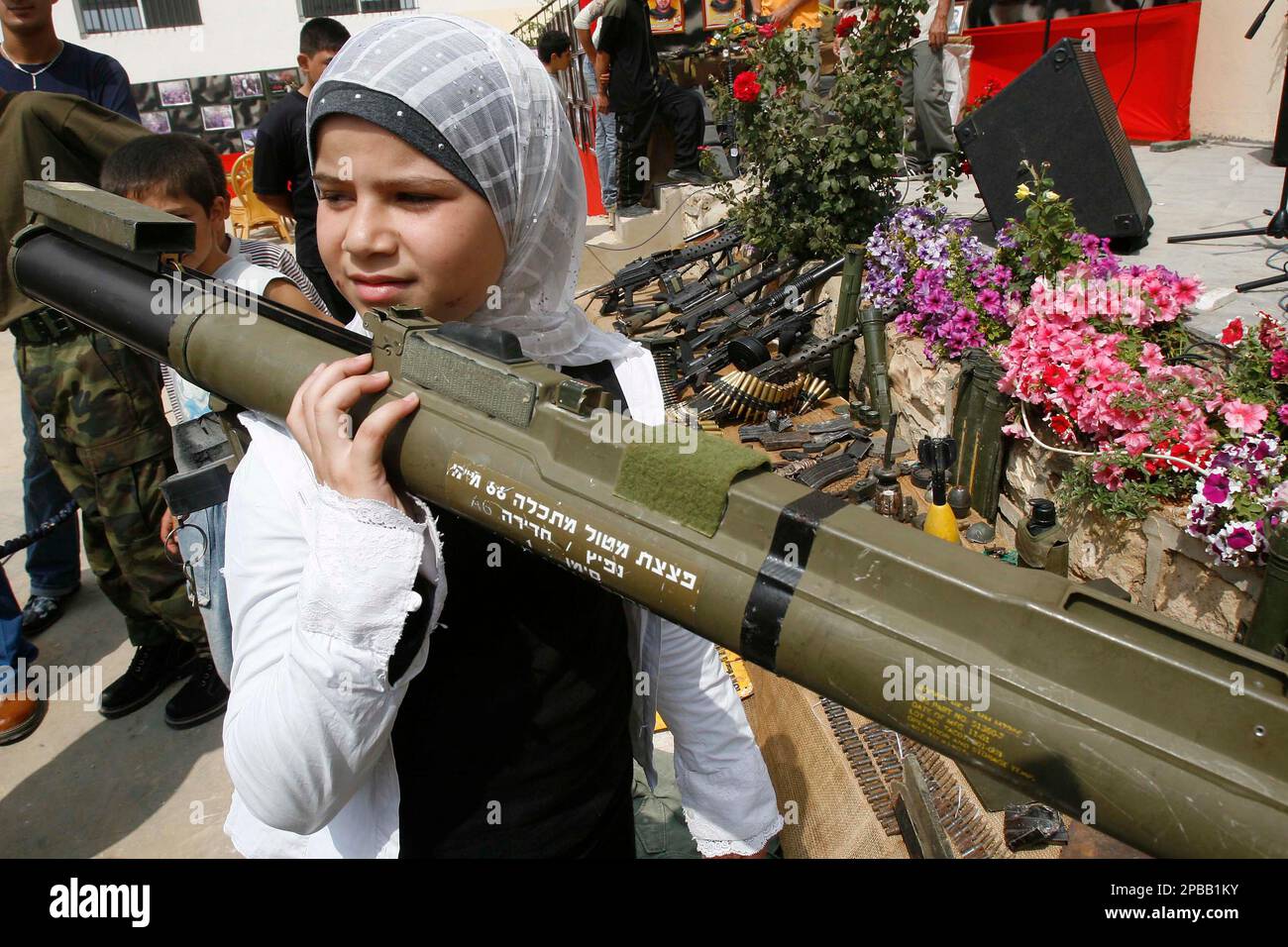 A Lebanese villager girl, holds an Israeli rocket launcher from the war ...