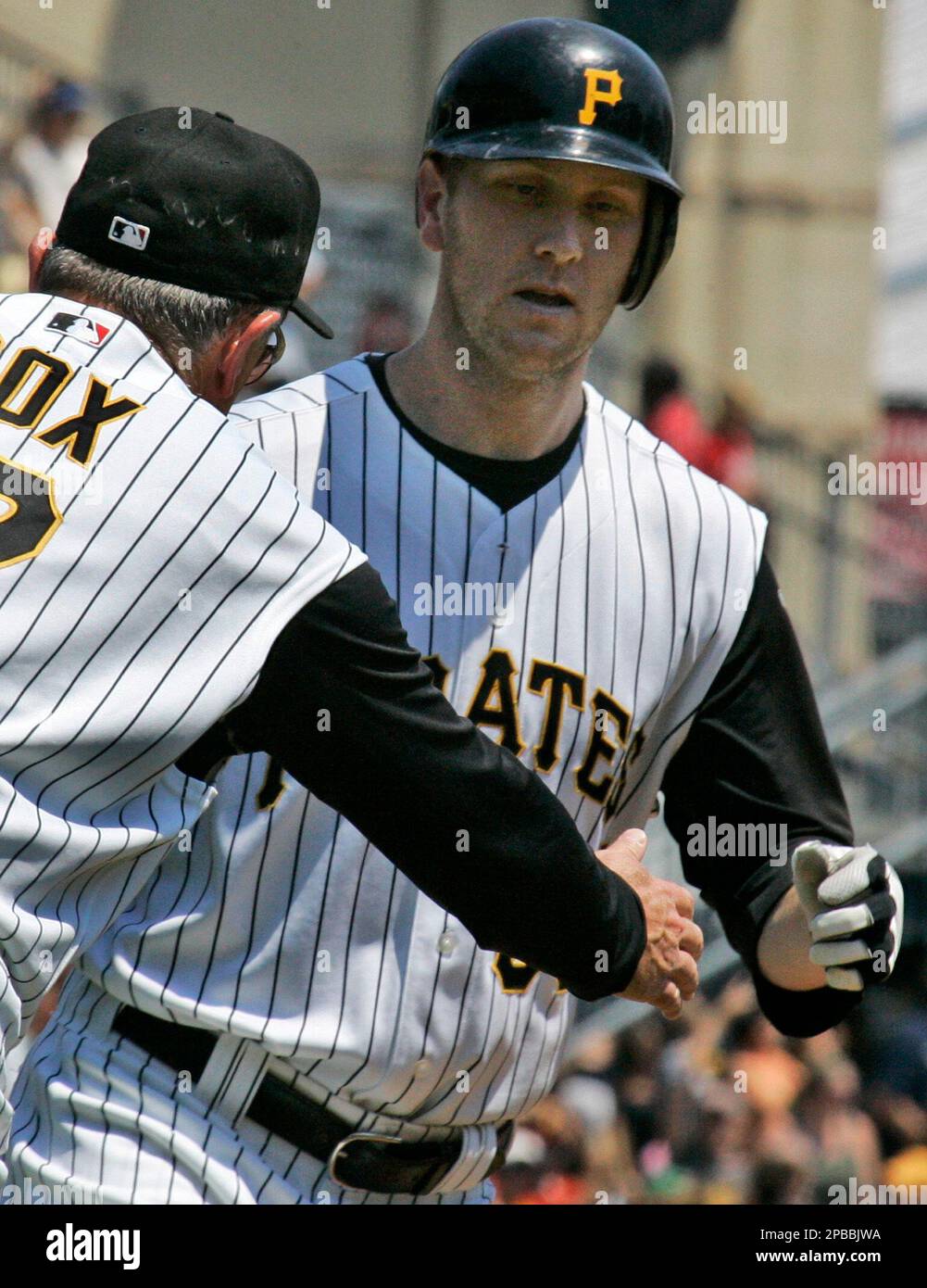 Pittsburgh Pirates' Jason Bay, right, is greeted by coach Jeff Cox as ...