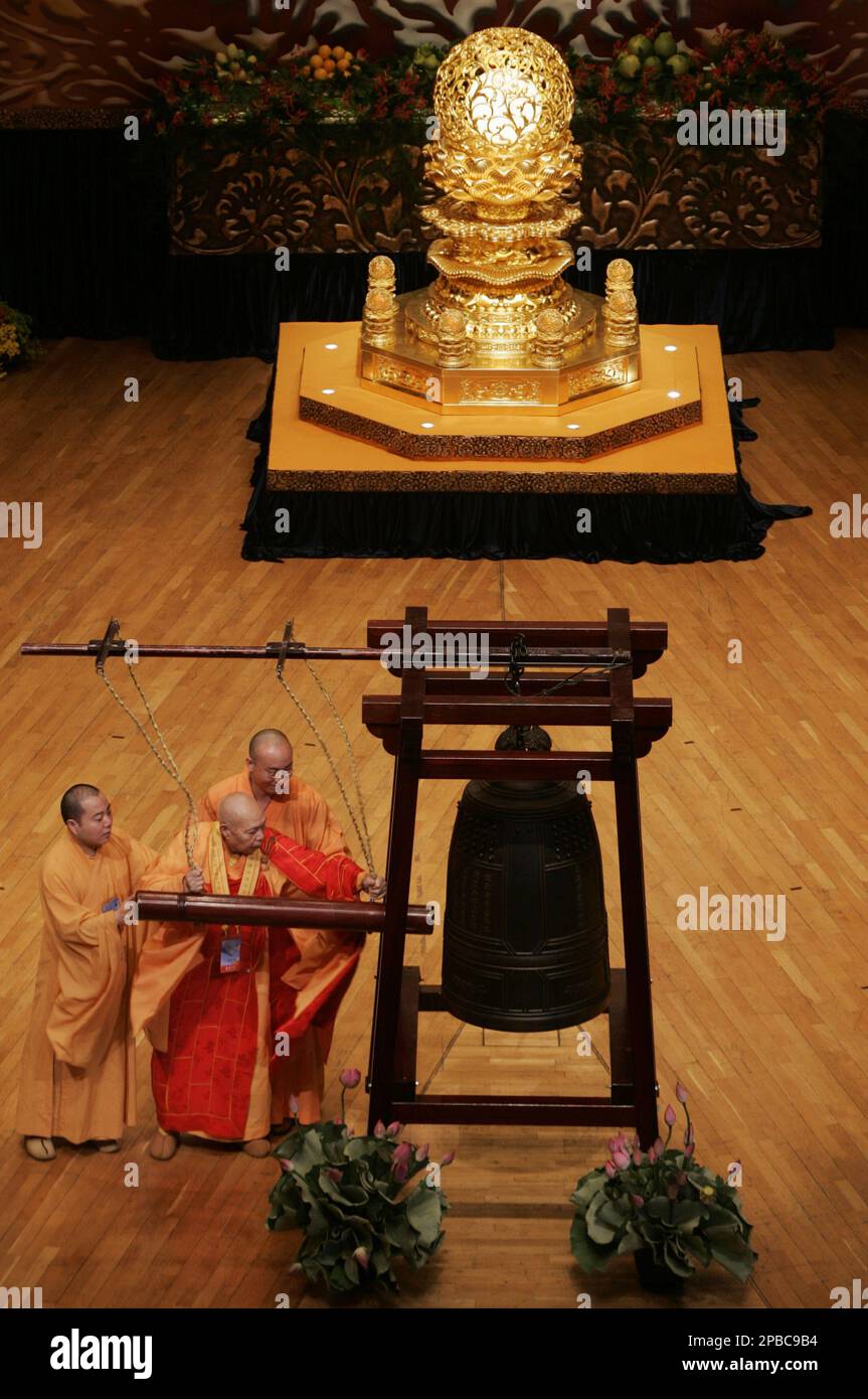 A Buddhist monk tolls the bell during a ceremony to pray for a better ...