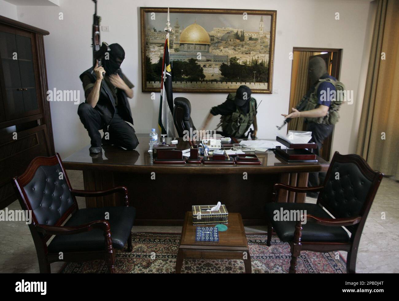 Palestinian militants from Hamas stand at the desk of Palestinian ...