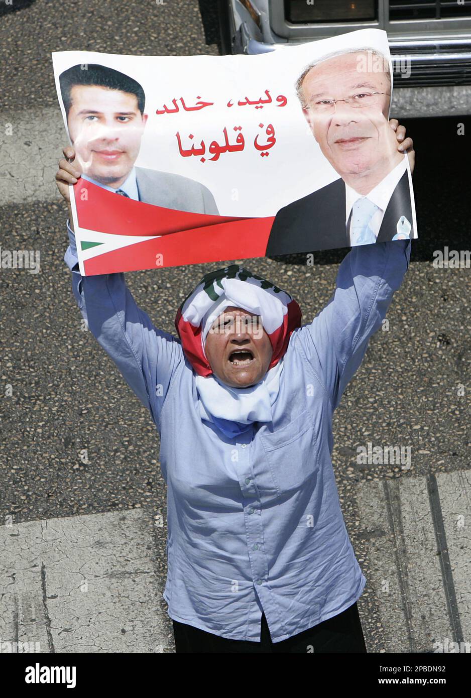 A Lebanese woman, holds poster portraits of slain anti-syrian lawmaker ...