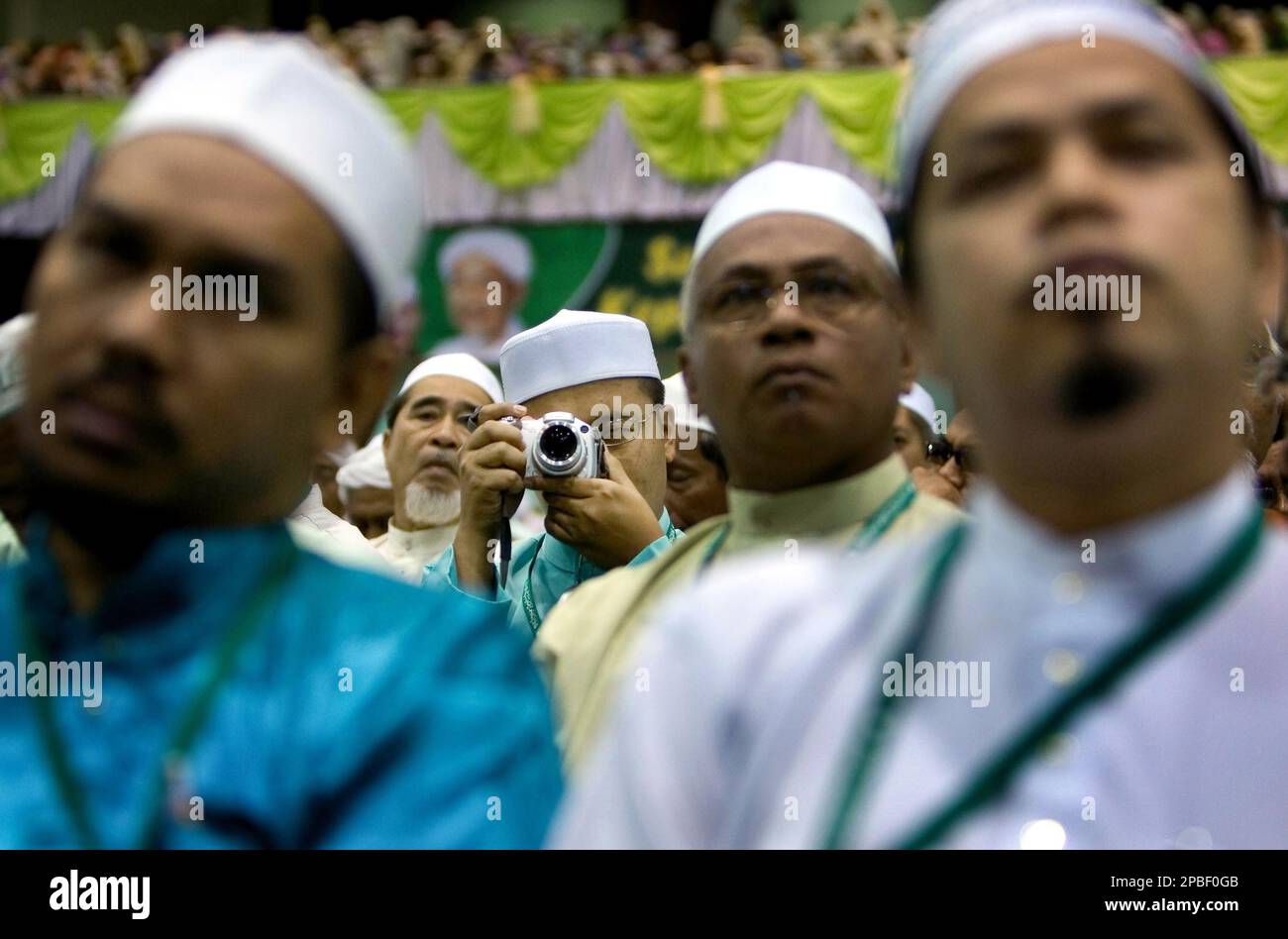 A party member, center, takes photograph during Abdul Hadi Awang ...