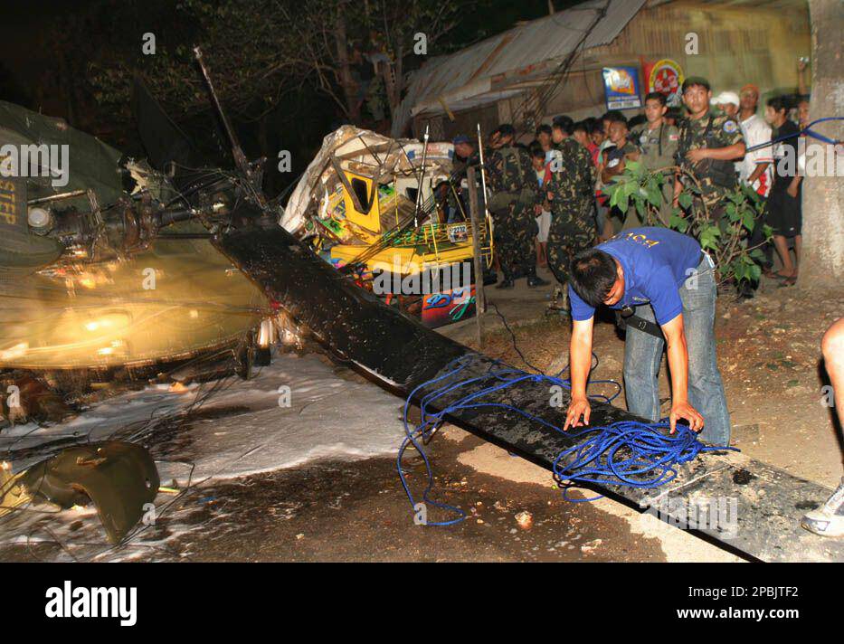 A rescuer secures a rotor blade of a Vietnam War-era Huey helicopter of ...