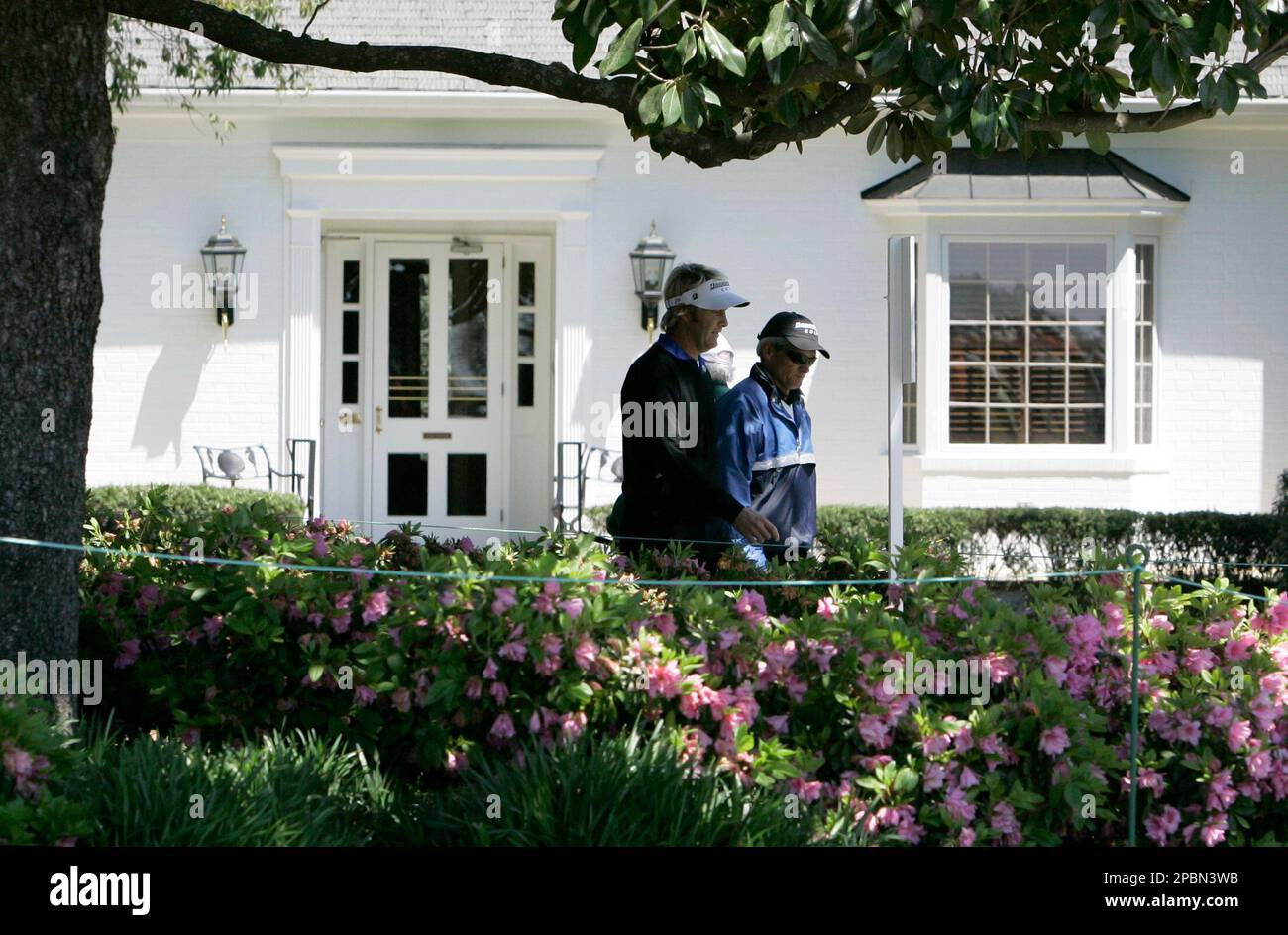 Stuart Appleby, from Australia, left, walks past Butler Cabin before ...