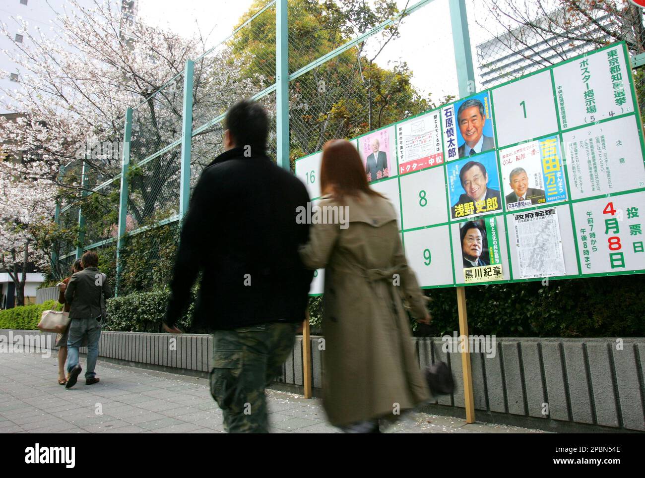 A couple walks past an official poster display stand for Tokyo ...