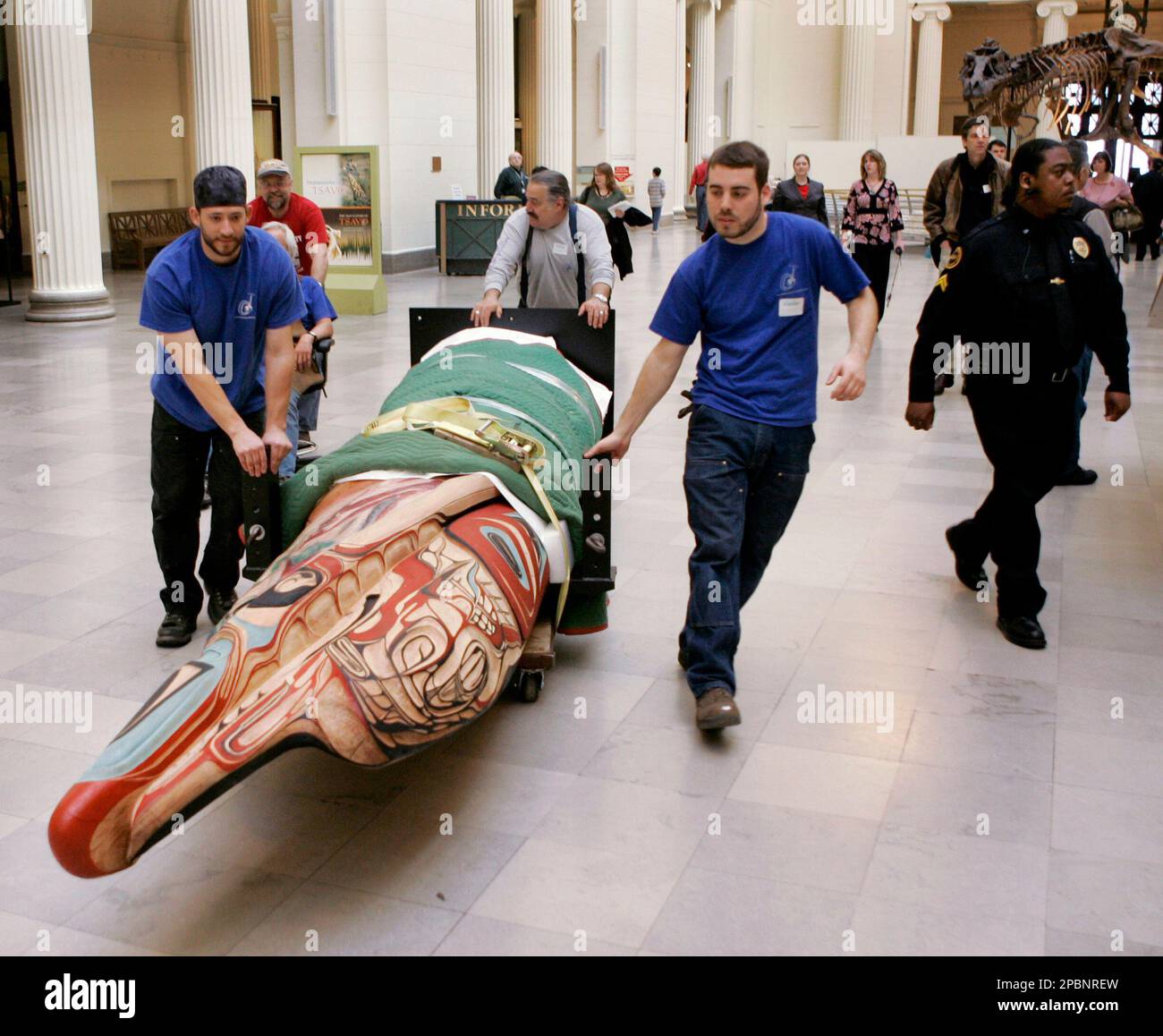 Workmen move a new 15-foot totem pole through the lobby of The Field ...