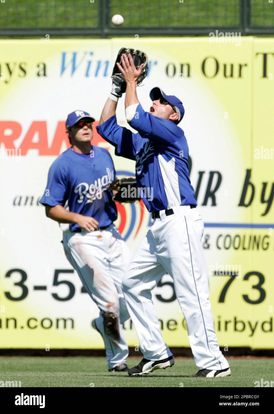 Kansas City Royals center fielder Mark Teahen, rear, looks on as right ...