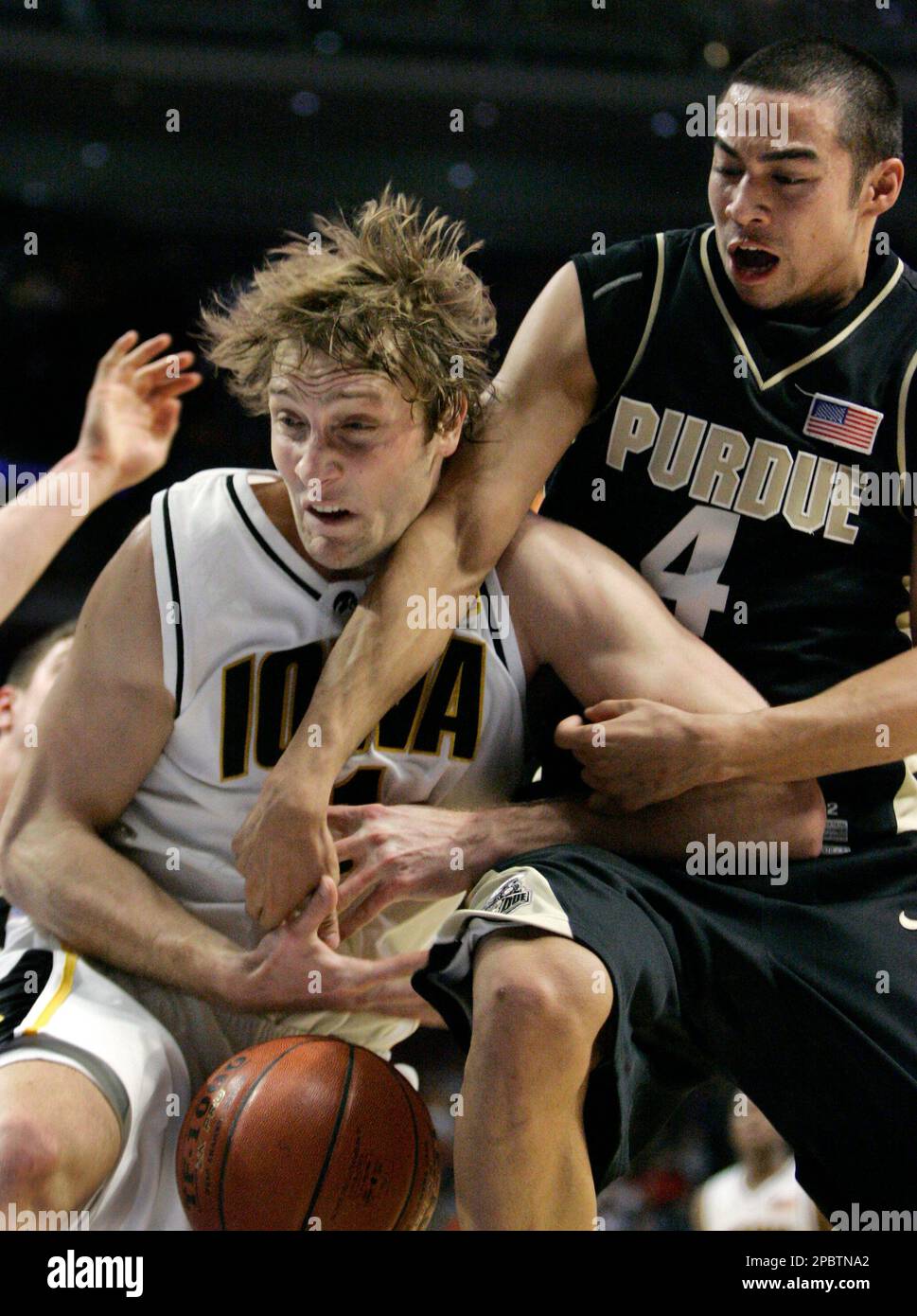 Purdue guard Chris Lutz, right, pokes the ball out of Iowa guard Adam ...