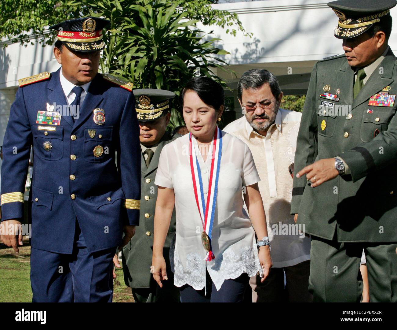 Philippine President Gloria Macapagal Arroyo, center, walks with ...