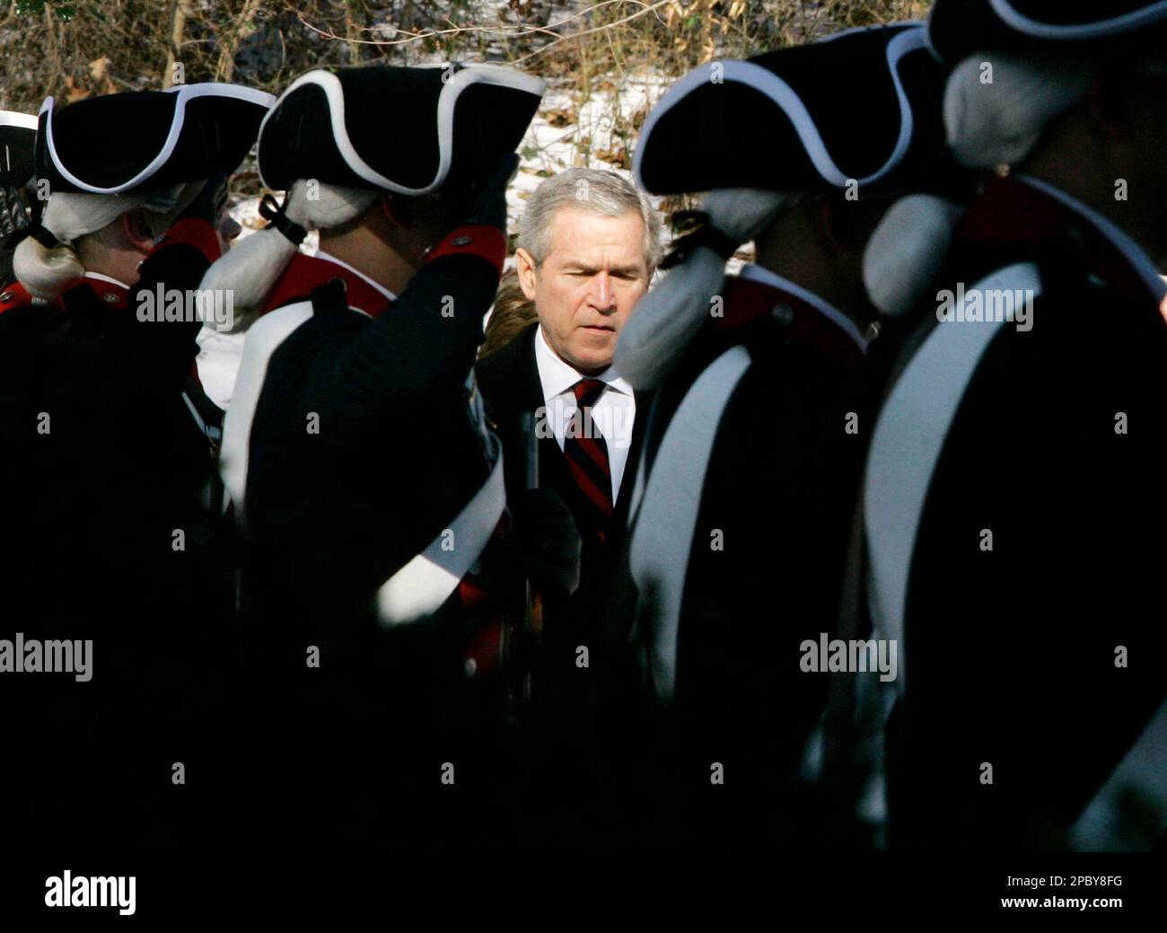 President Bush, center, walks past a cordon of honor guard members ...