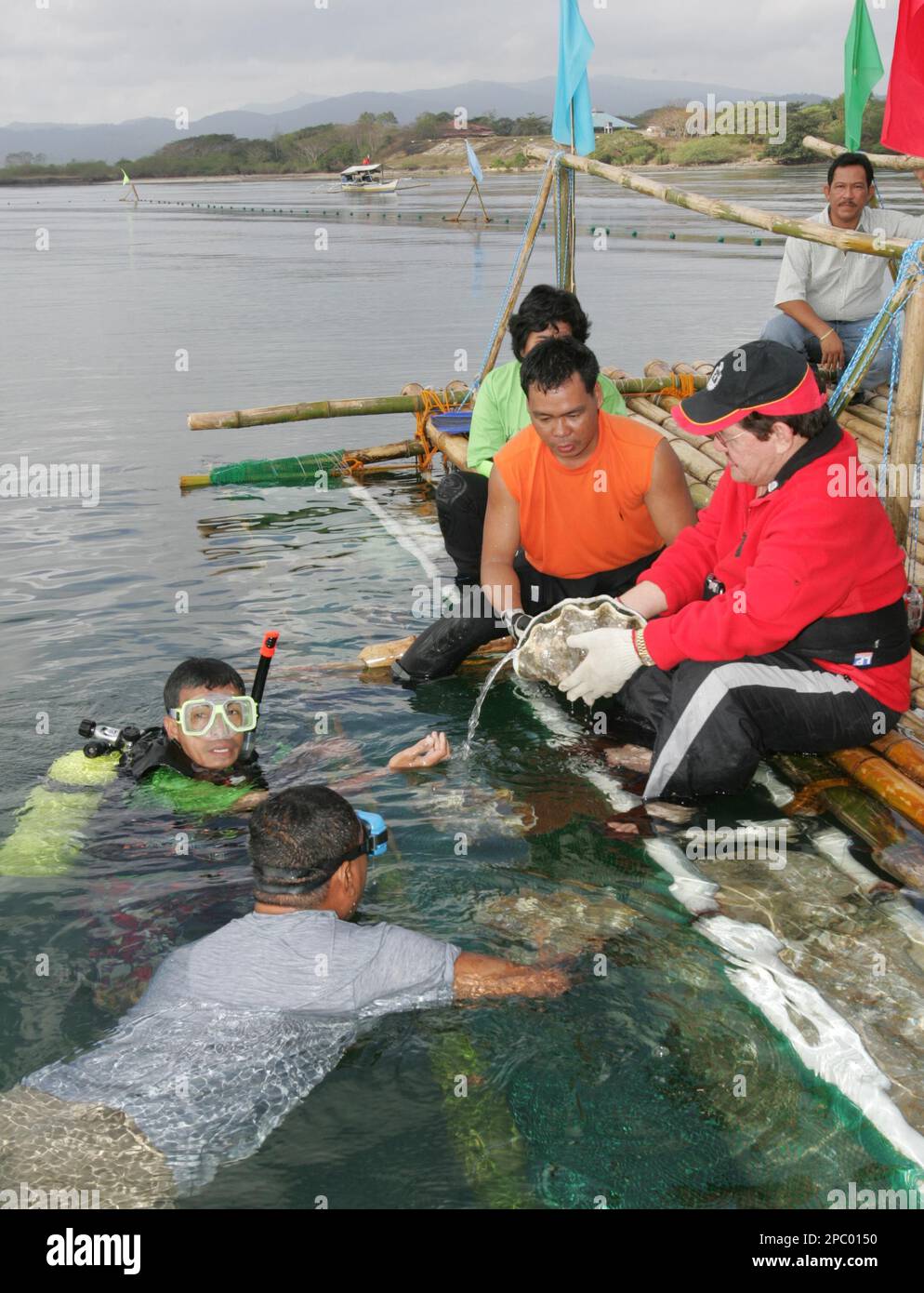 A giant clam, locally known as "Taklobo," squirts as Mayor Edward ...