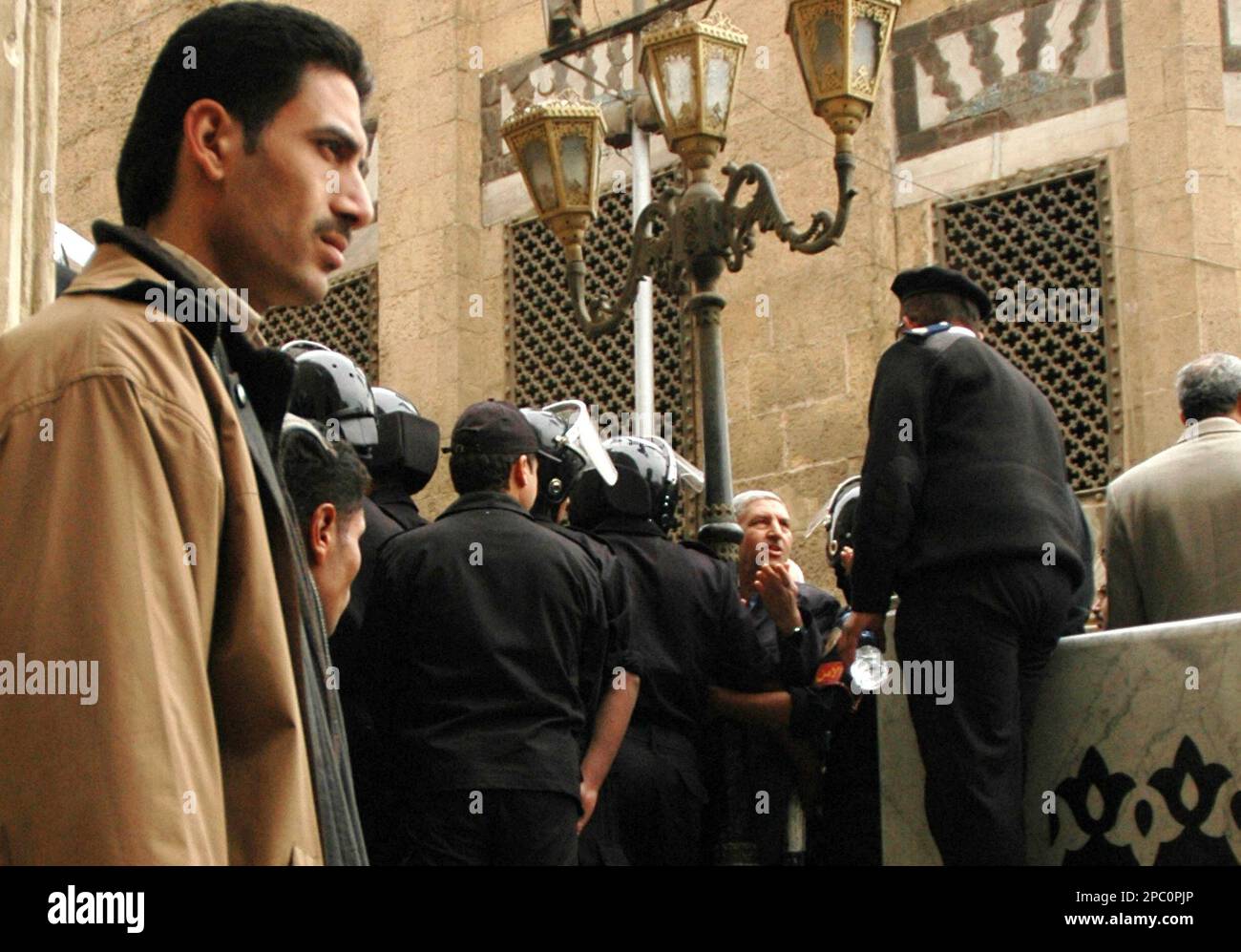 Riot police and a plain-clothed police officer, left, prevent a man ...