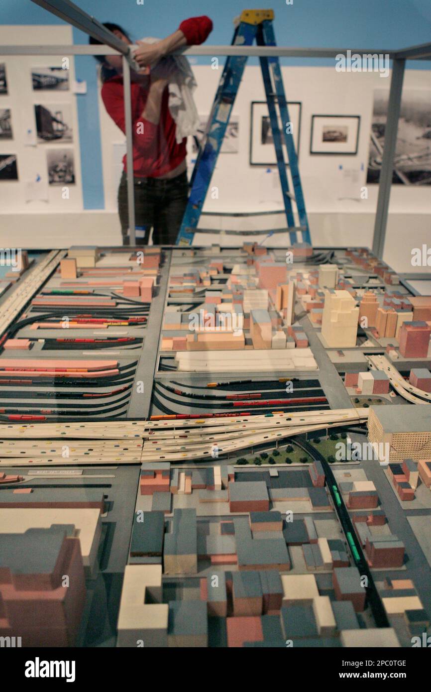 An employee cleans the glass in front of a model of the Mid-Manhattan ...