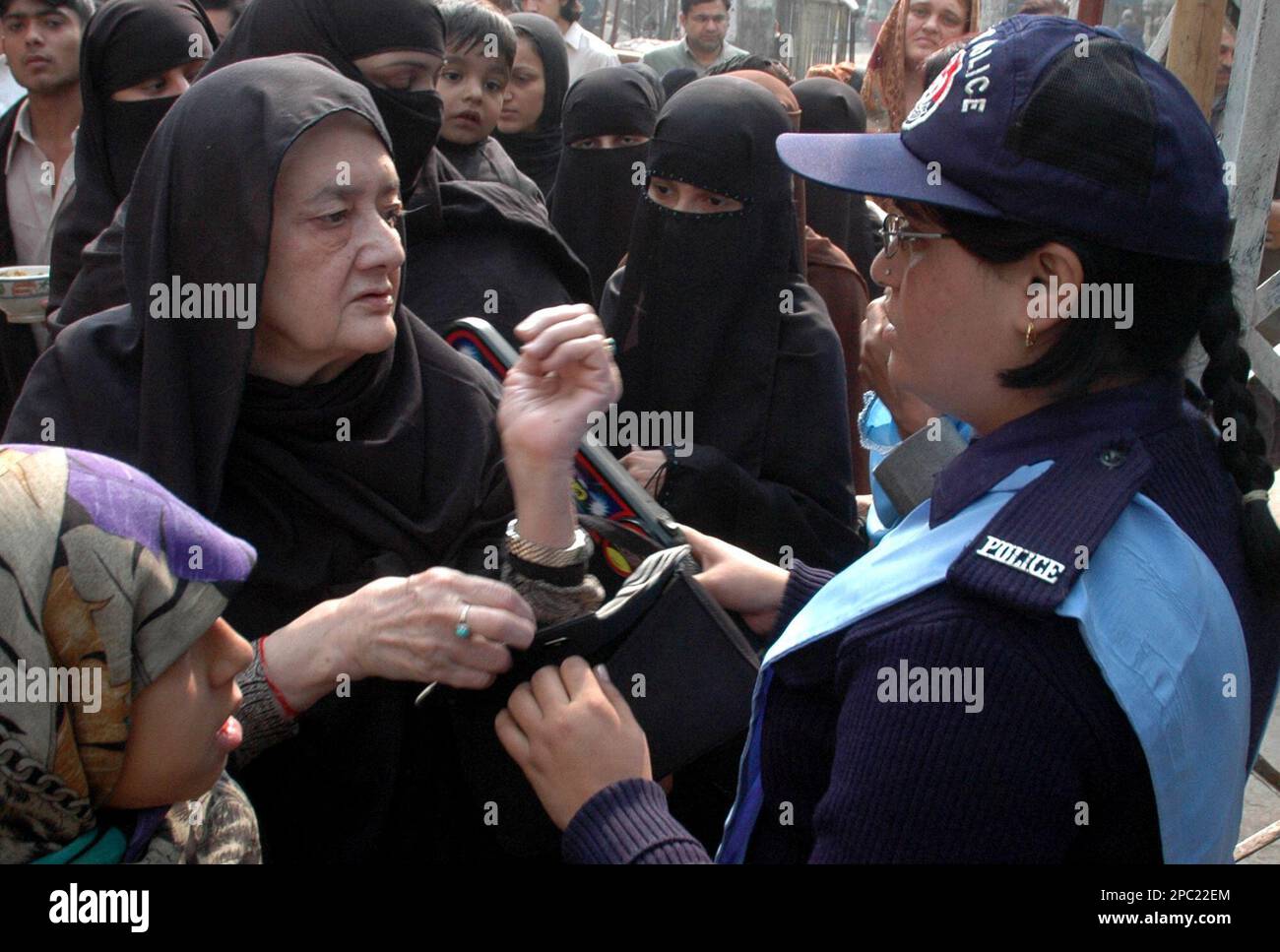 A Pakistani police officer checks belongings of Shiite Muslims during a ...