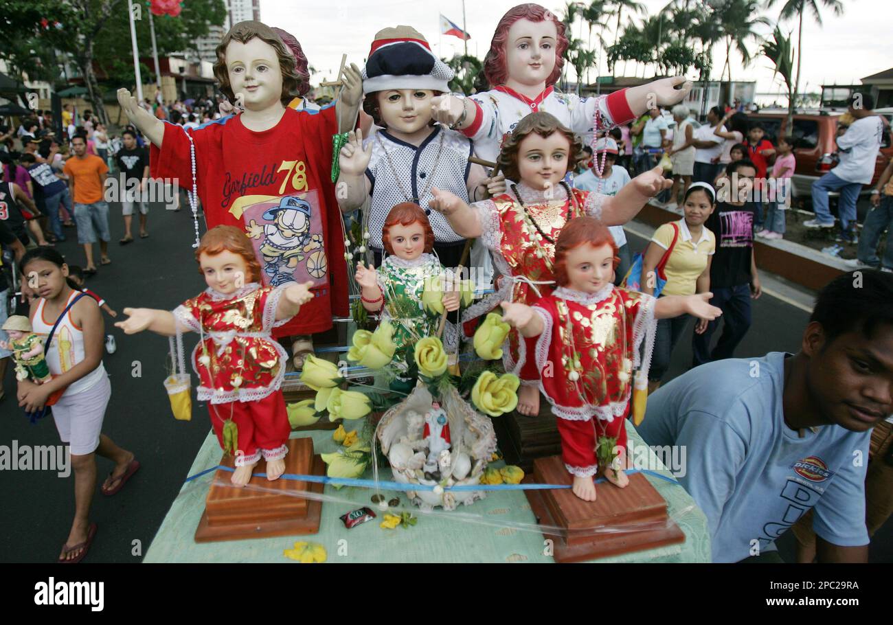 A Filipino devotee with various sizes of the image of Santo Nino, or ...