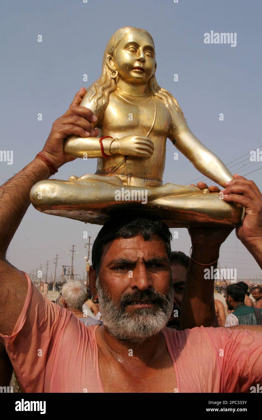 A Sadhu, or Hindu holy man, carries an idol of Hindu Giod Chandra, at ...