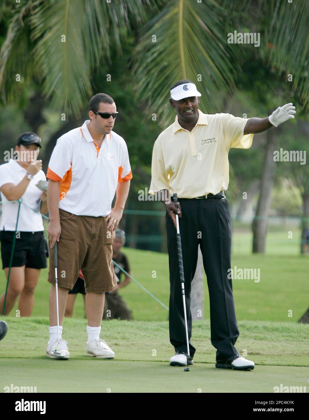 Actor Adam Sandler, left, gets help reading the green from Vijay Singh ...