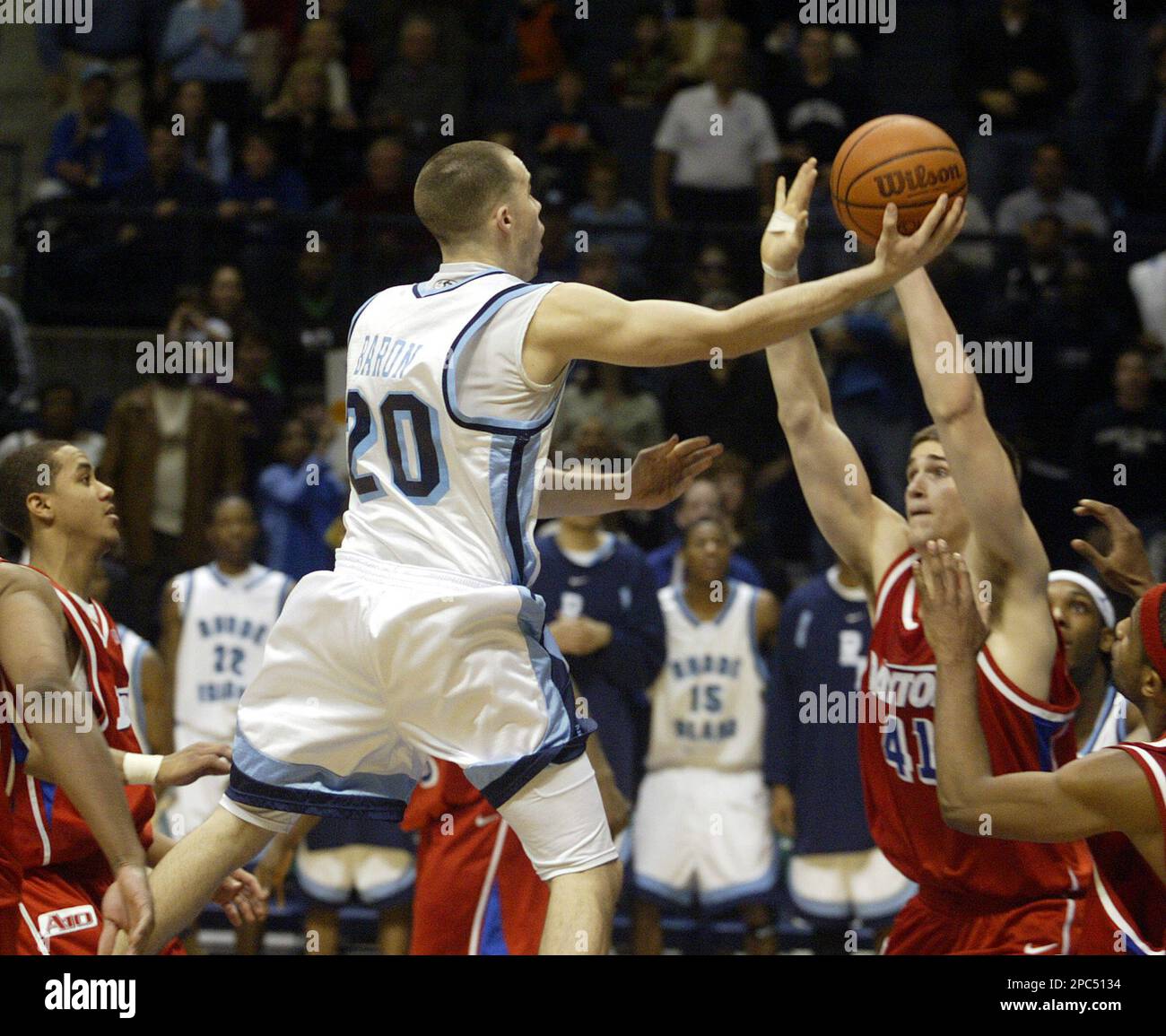 Rhode Island's Jimmy Baron (20) drives to the hoop over Dayton's Kurt ...